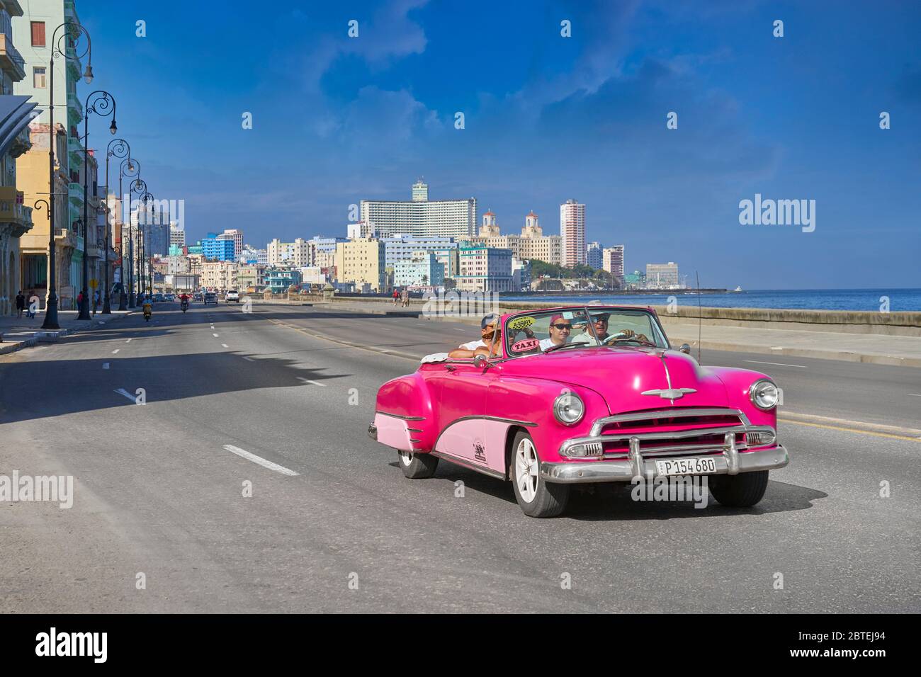 Classic American pink car driving along the Malecon, Havana, Cuba Stock ...