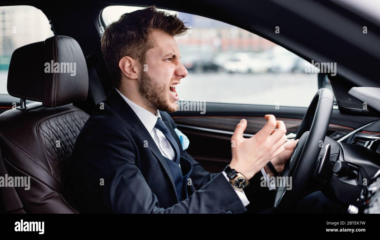 Angry young businessman driving alone in his new car Stock Photo - Alamy