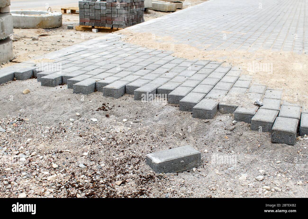 construction of a new modern sidewalk made of tiles outdoor on sunny ...