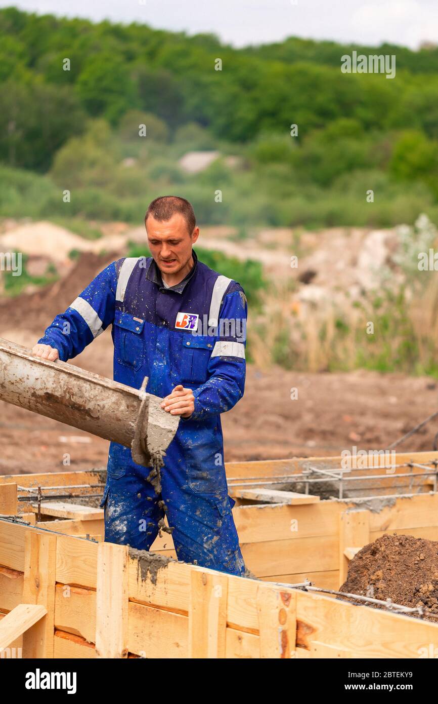 Construction worker laying cement or concrete into the foundation ...
