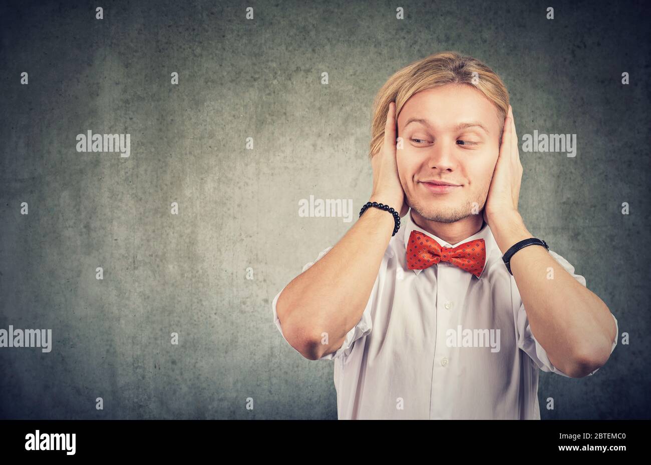 Young happy man avoiding background noise and rumours Stock Photo - Alamy
