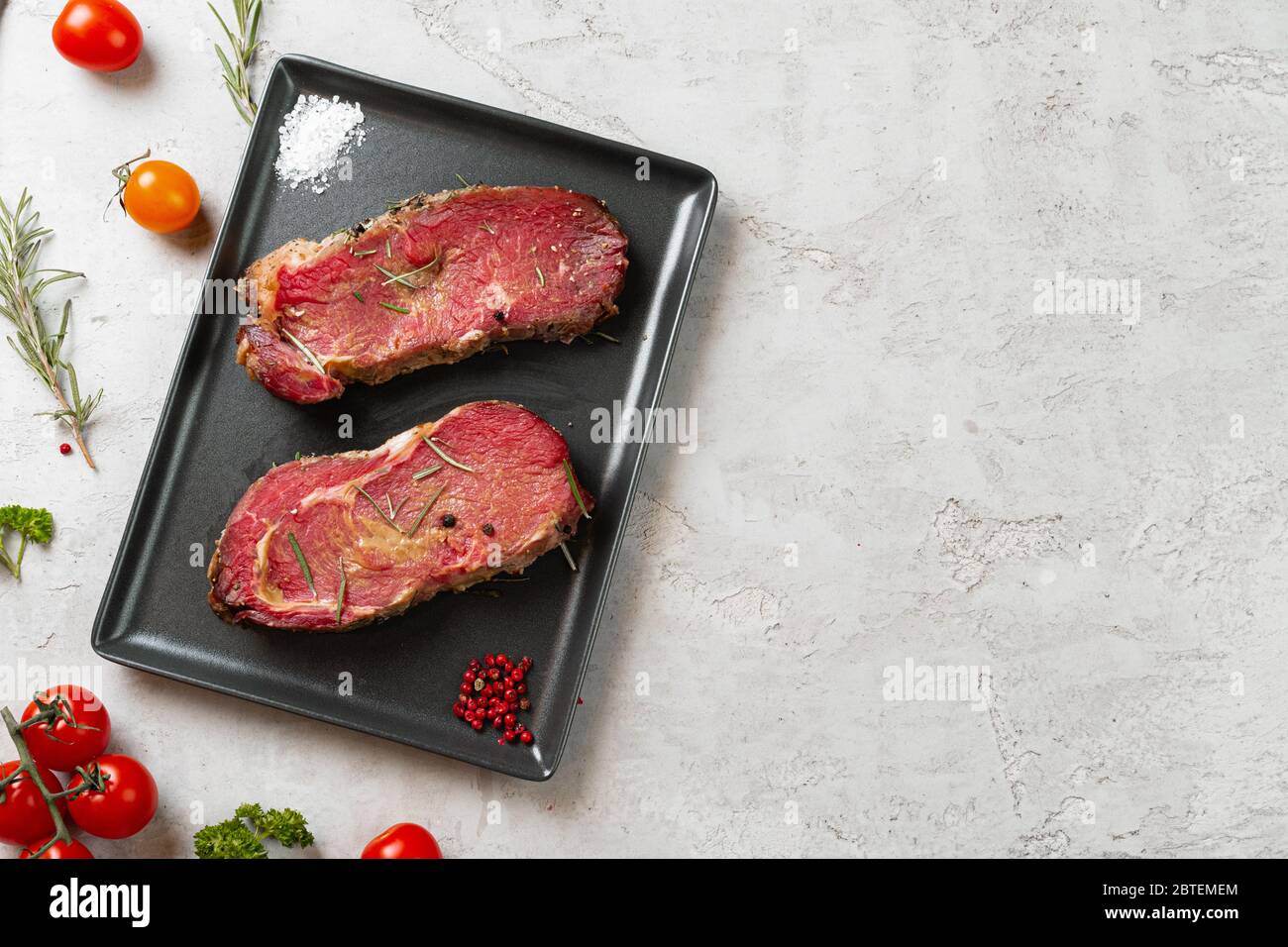 Marinated raw steaks on stone table with spices Stock Photo - Alamy