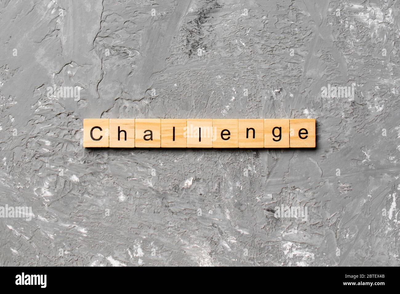 CHALLENGE word written on wood block. CHALLENGE text on cement table ...