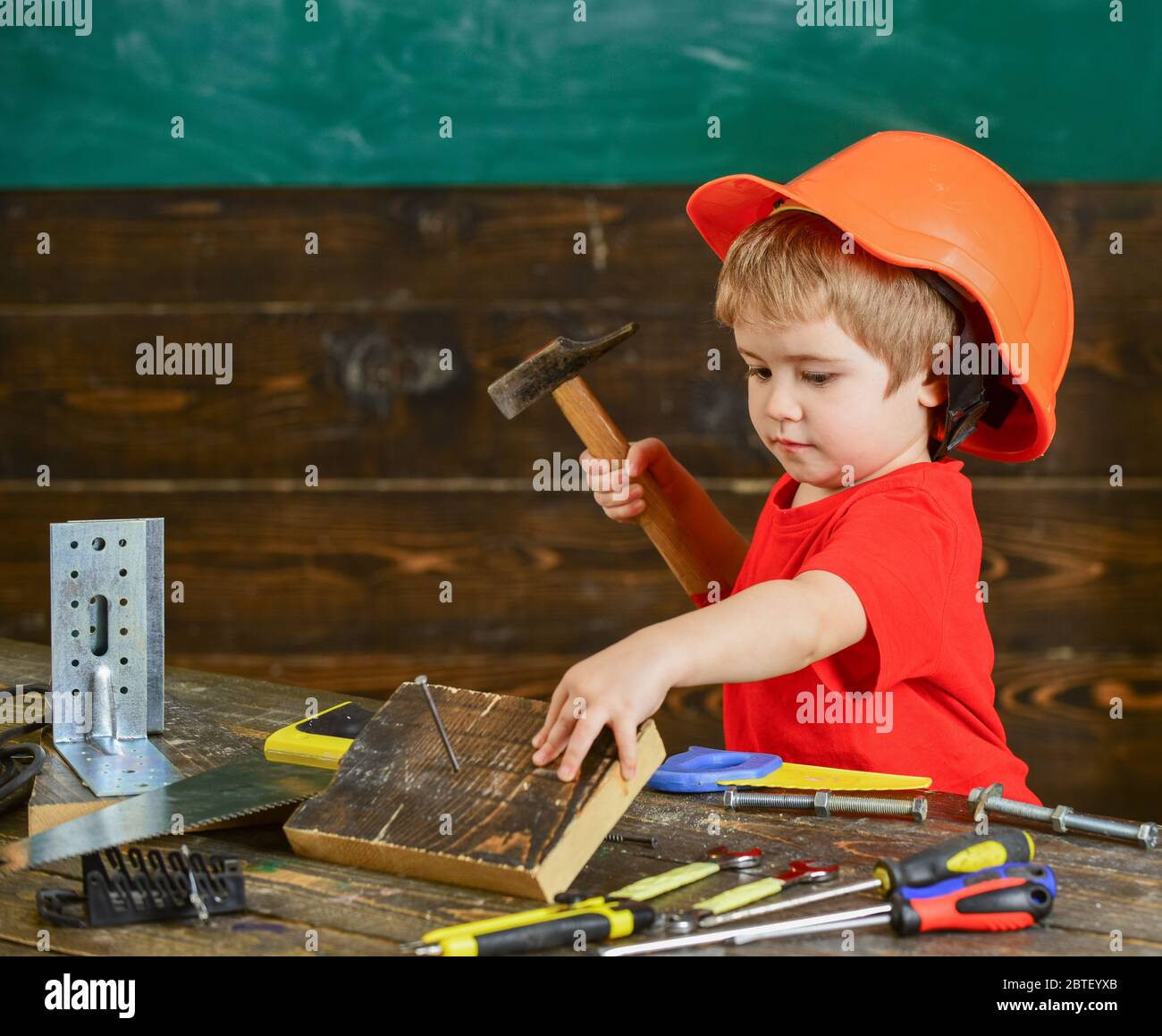 Handcrafting concept. Toddler on busy face plays with hammer tool at ...