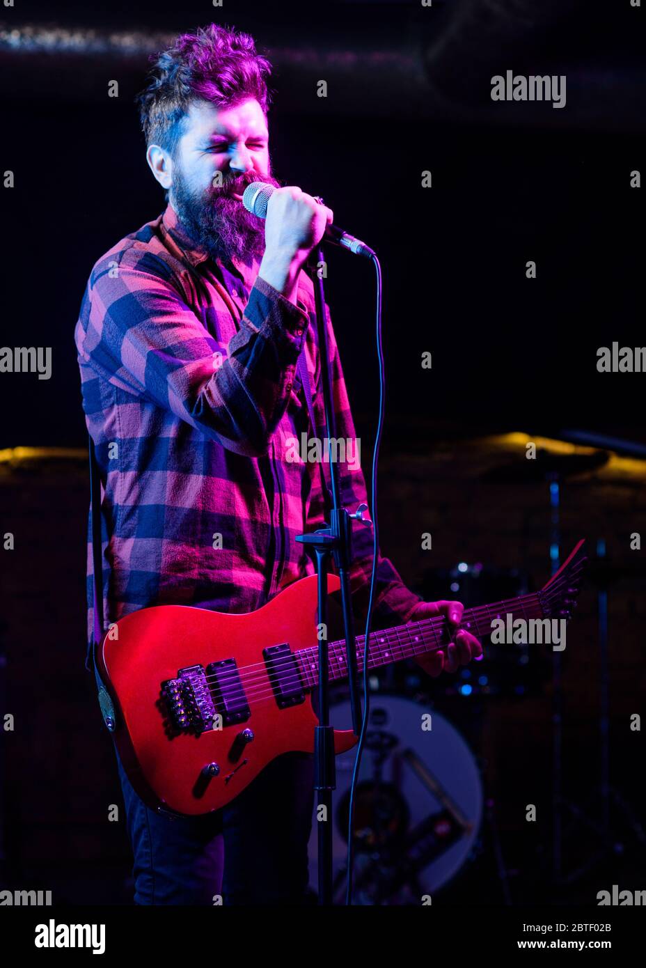 Frontman concept. Musician with beard play electric guitar lighted by ...