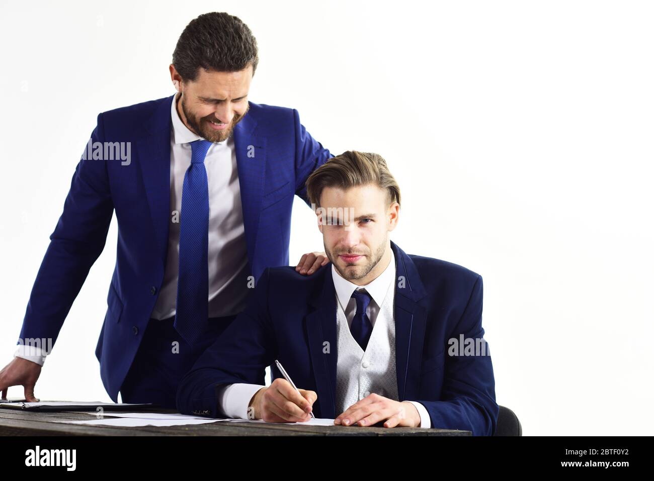 Director helps young man with report. Businessman and his assistant ...