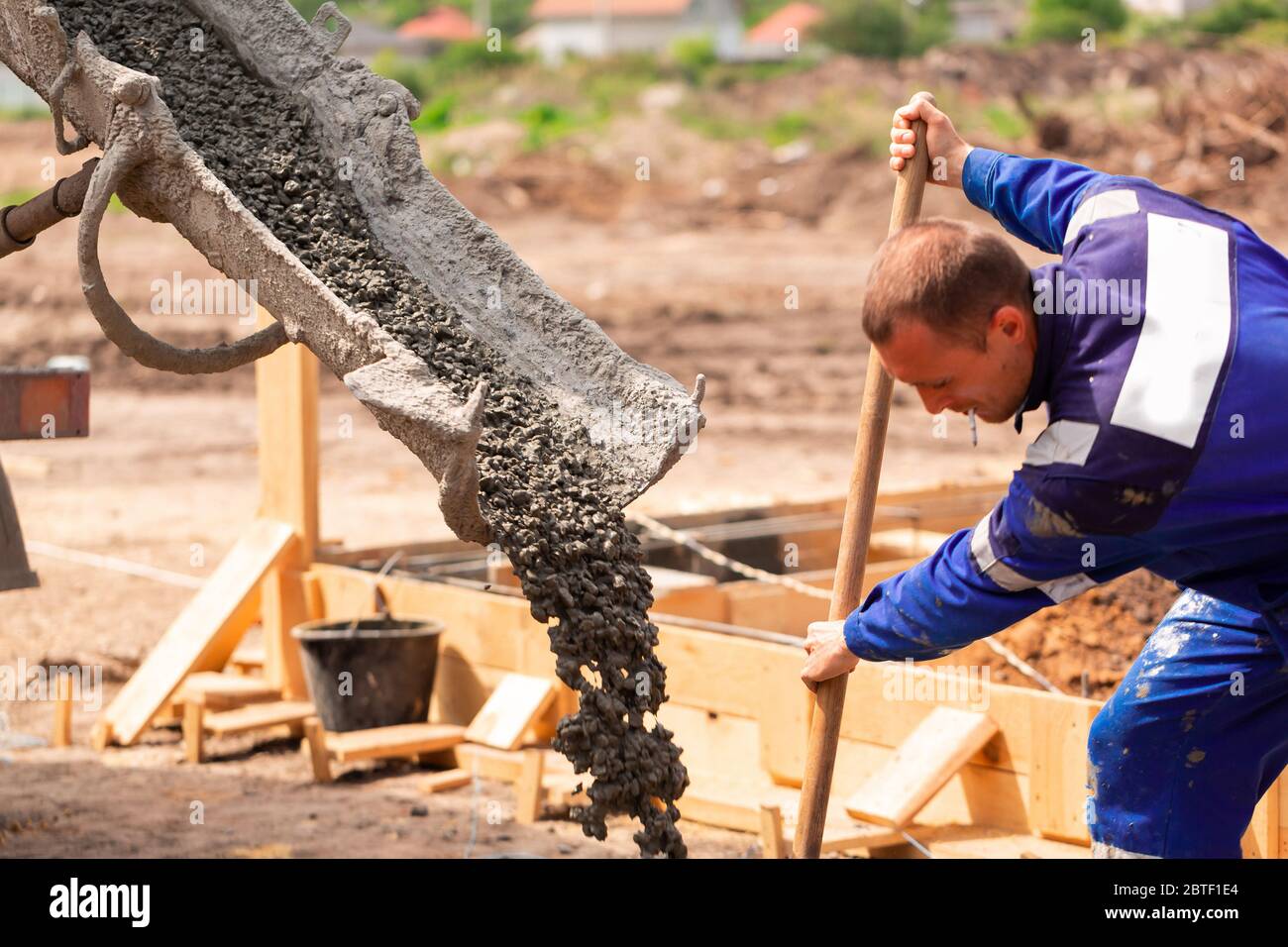 Construction worker laying cement or concrete into the foundation ...