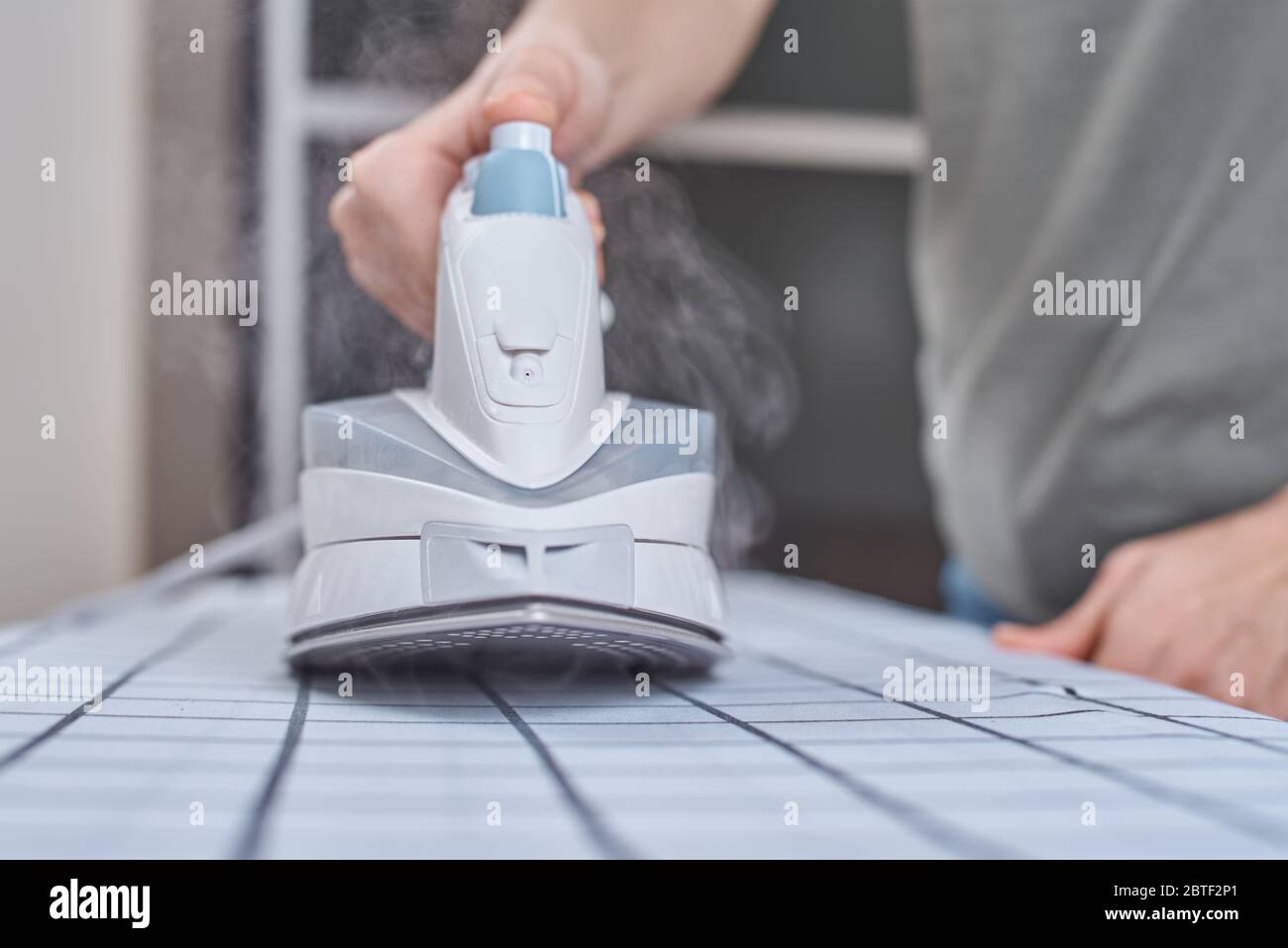 Woman ironing clothes on ironing board with modern iron Stock Photo - Alamy