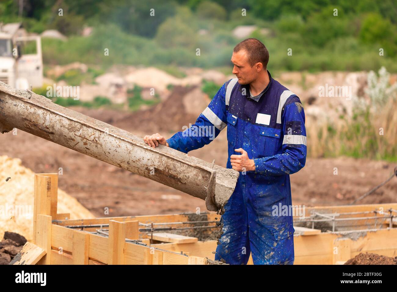 Construction worker laying cement or concrete into the foundation ...