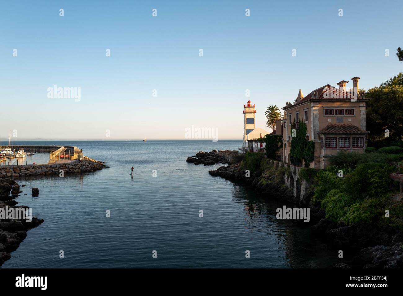 Europe, Portugal, Caiscas. A man is paddling in the water below the ...
