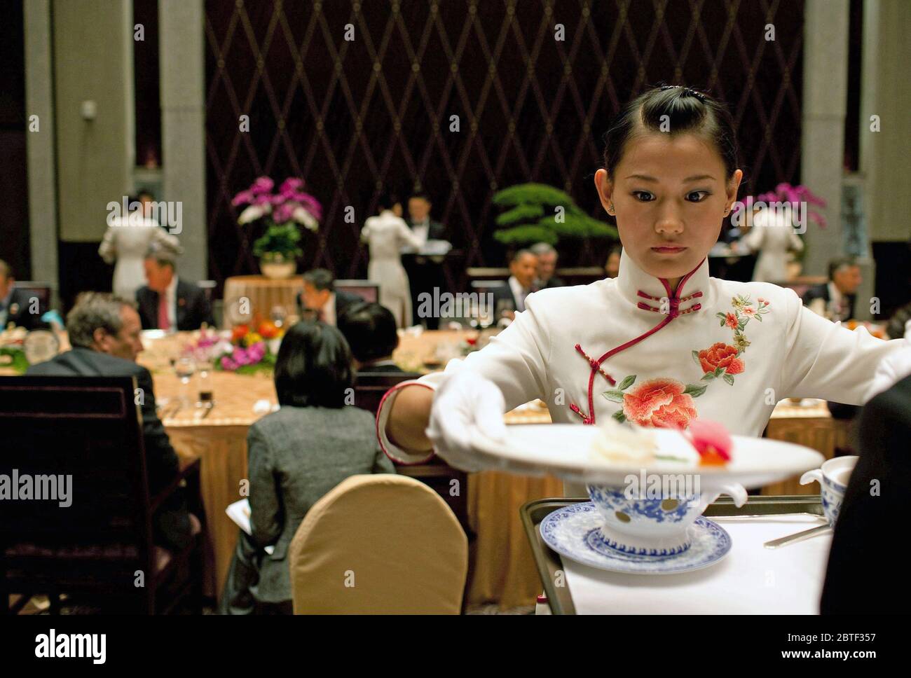 Wait staff prepare to serve plates of food at a working lunch with ...