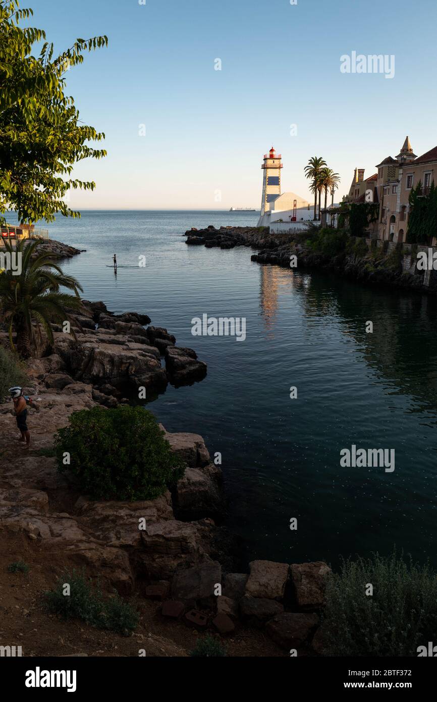 Europe, Portugal, Caiscas. A man is paddling in the water below the ...