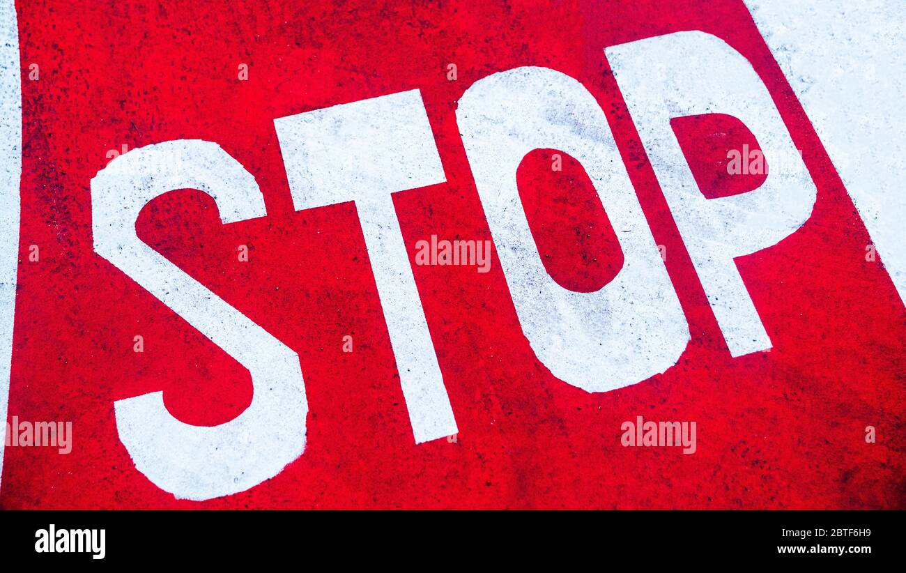 Diagonal stop signal painted on the red asphalt of a road Stock Photo ...