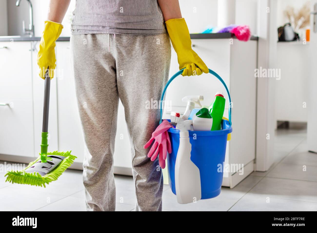 Woman holding in hands bucket with bottles of detergent, cleaning ...