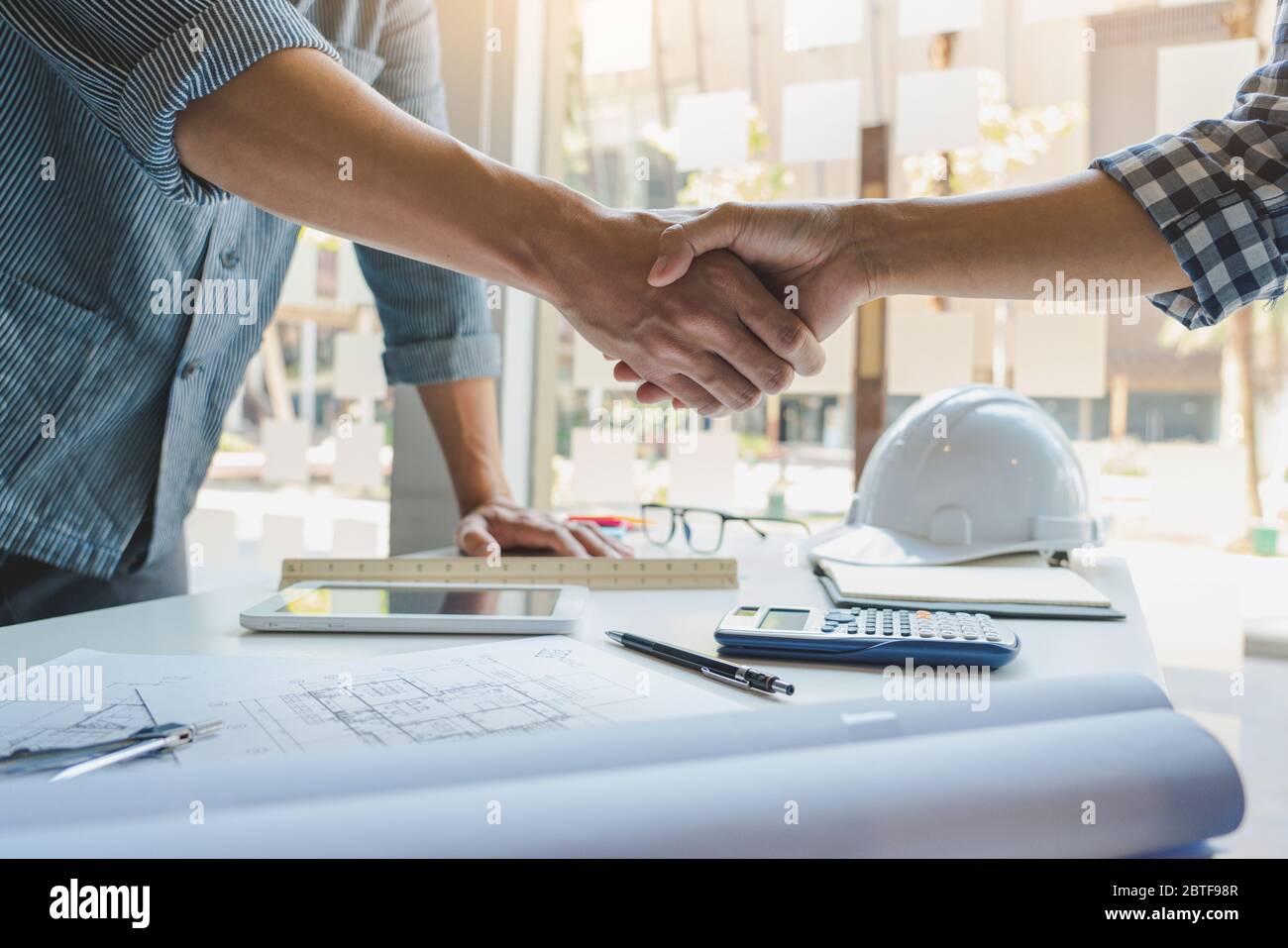 Architect and engineer construction workers shaking hands while working ...