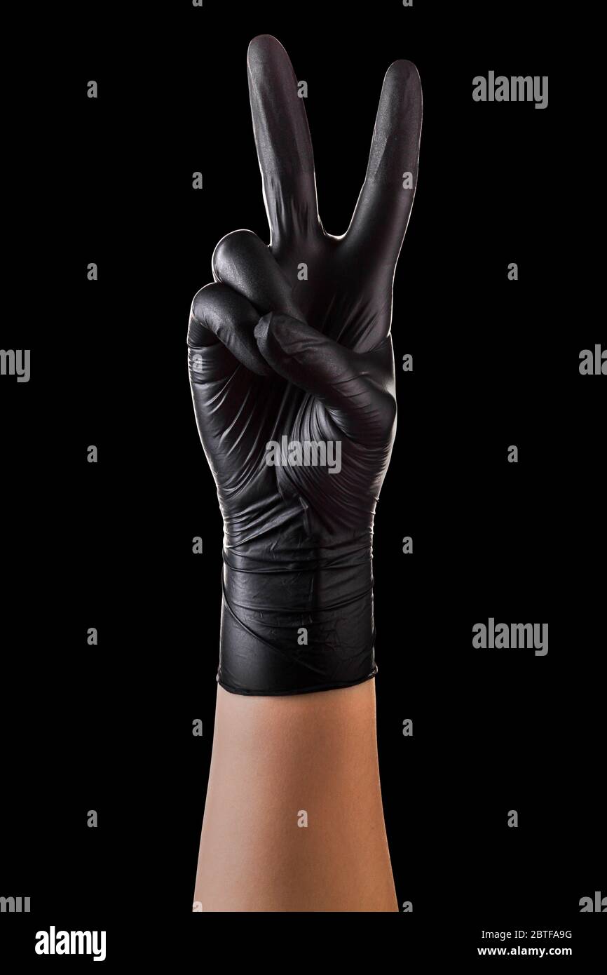 Hand in black gloves showing two fingers up in peace or victory symbol ...