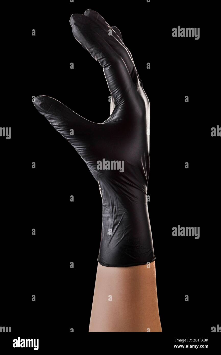 Hand in black gloves holding something with two fingers isolated on ...