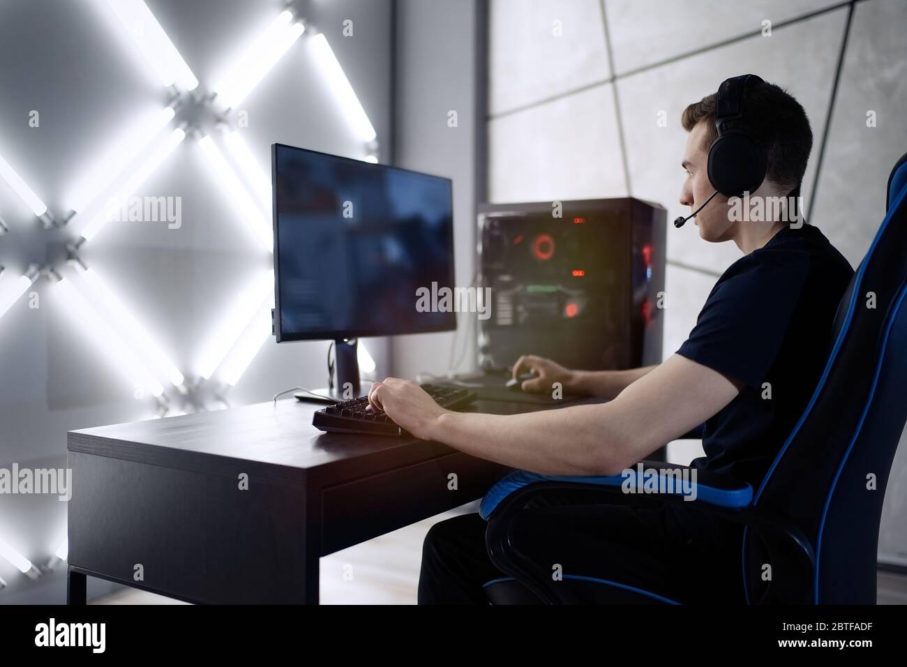 Professional gamer in his expensive studio having live stream playing ...