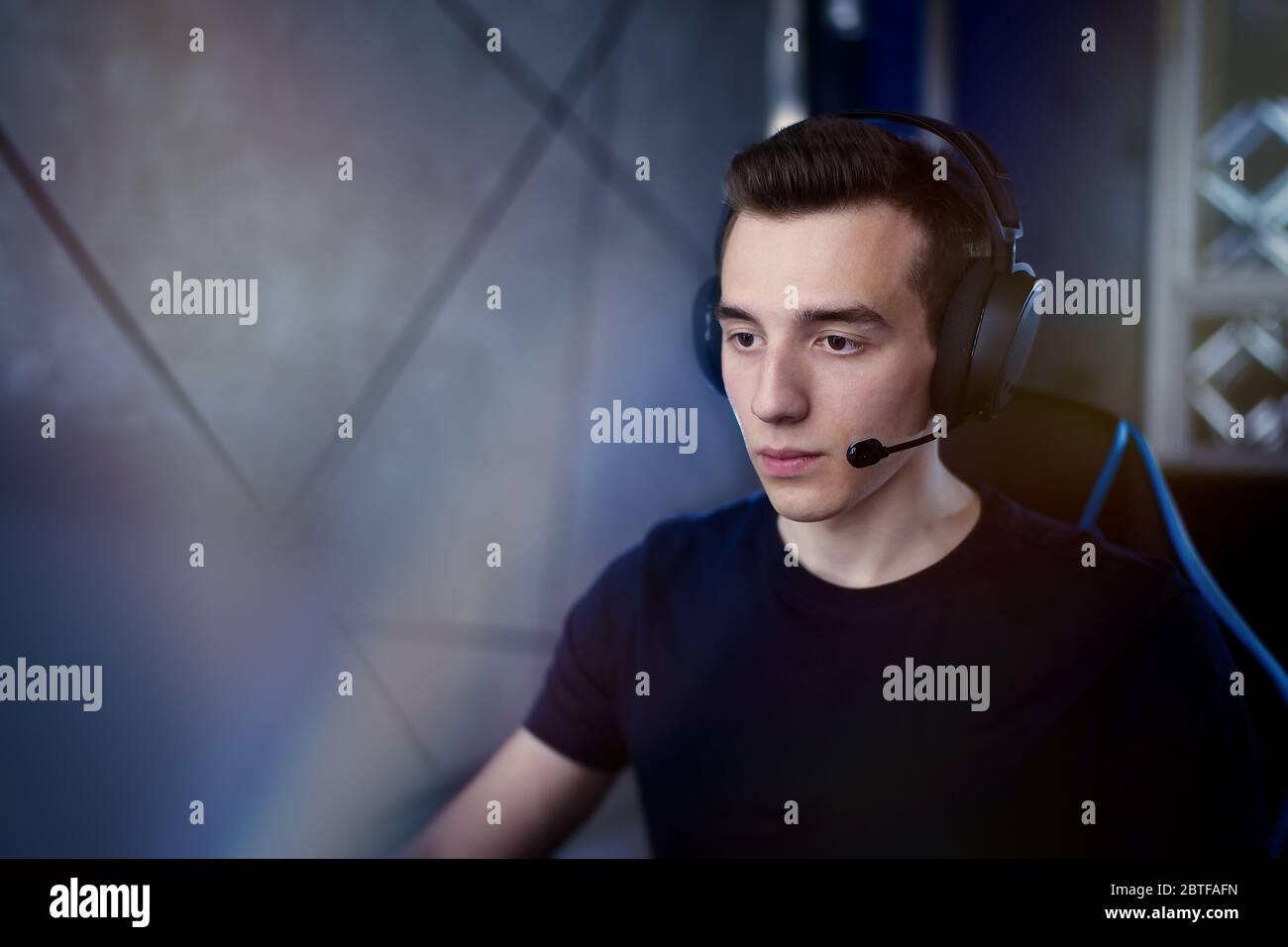 Portrait of professional gamer playing online video game at night time ...