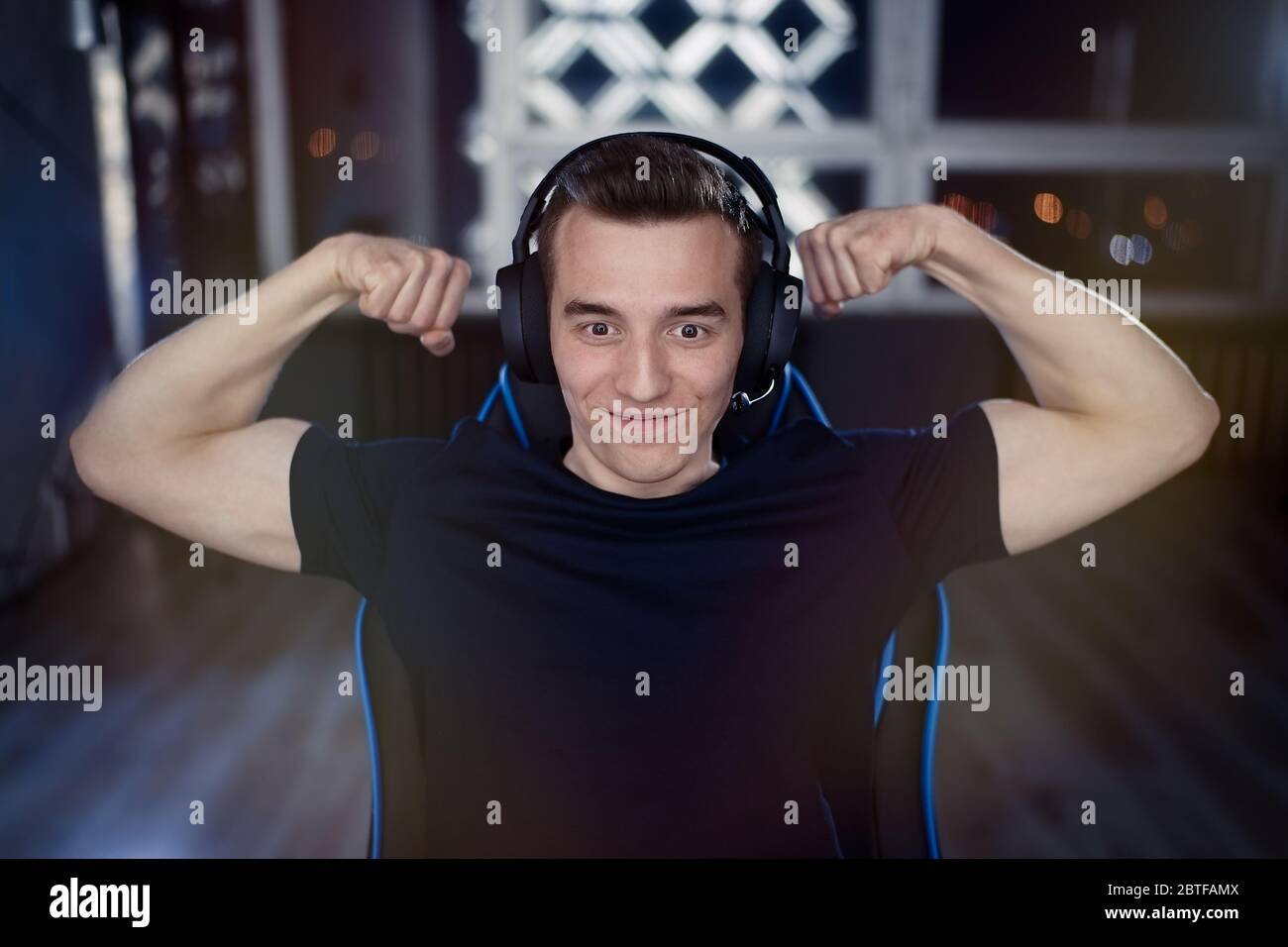 Portrait of ecstatic gamer guy in headphones screaming and rejoicing ...