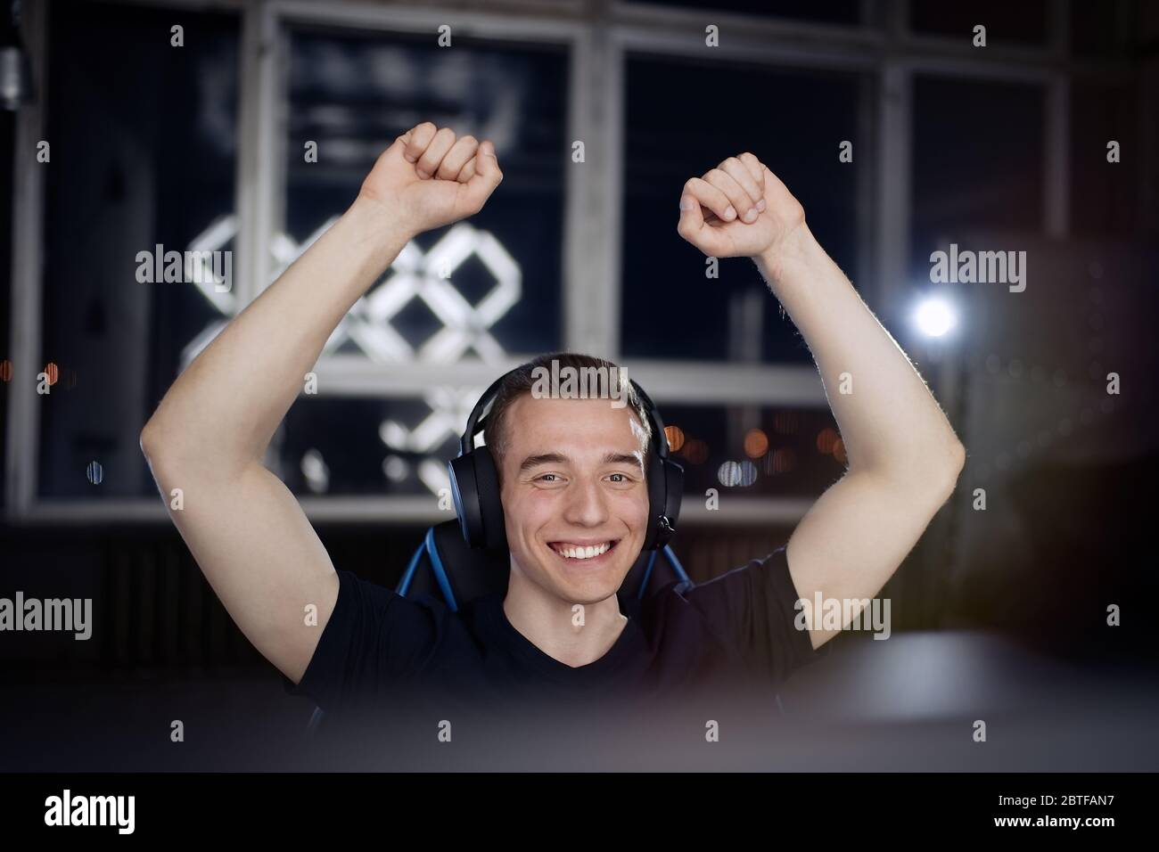 Portrait of ecstatic gamer guy in headphones screaming and rejoicing ...