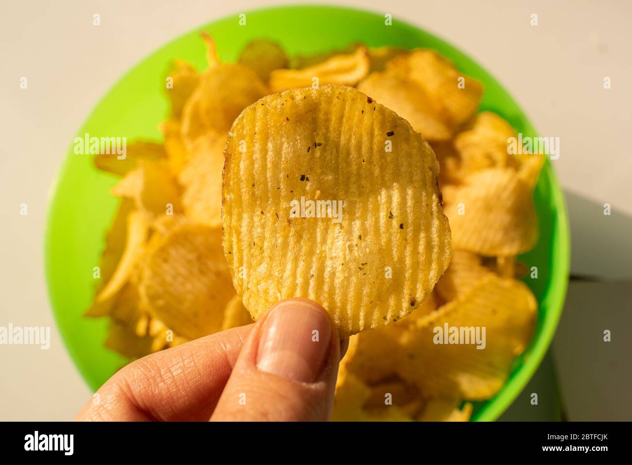 hand takes 1 chips from a plate with chips Stock Photo - Alamy