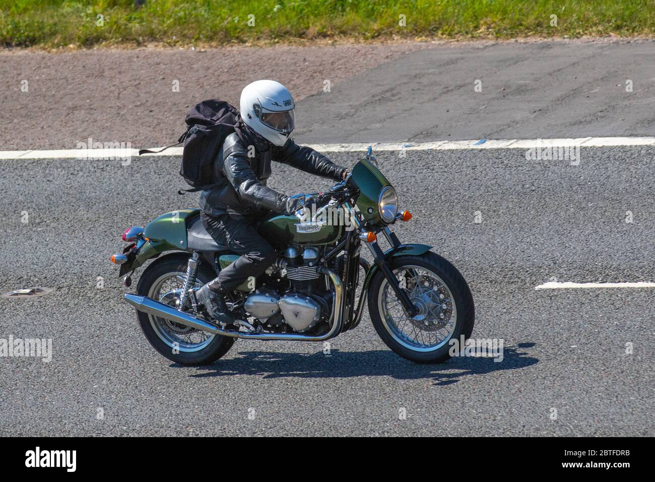 Green two cylinder Triumph Motorbike rider; two wheeled transport ...