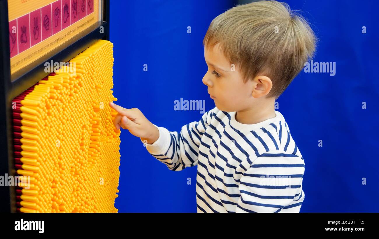 Portrait of little toddler boy playing educational game in museum of ...