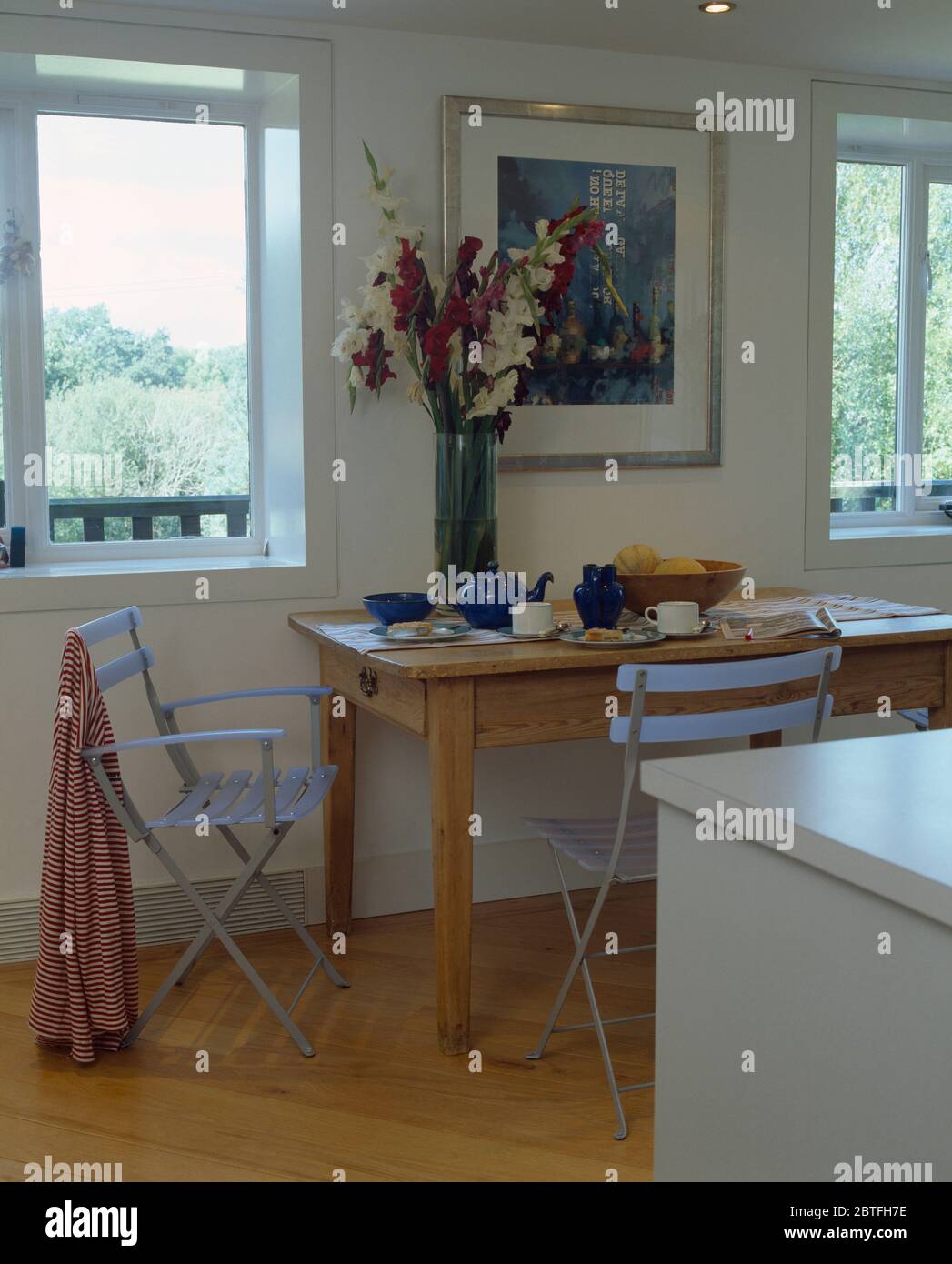 Simple chairs at plain wood table in modern kitchen Stock Photo - Alamy