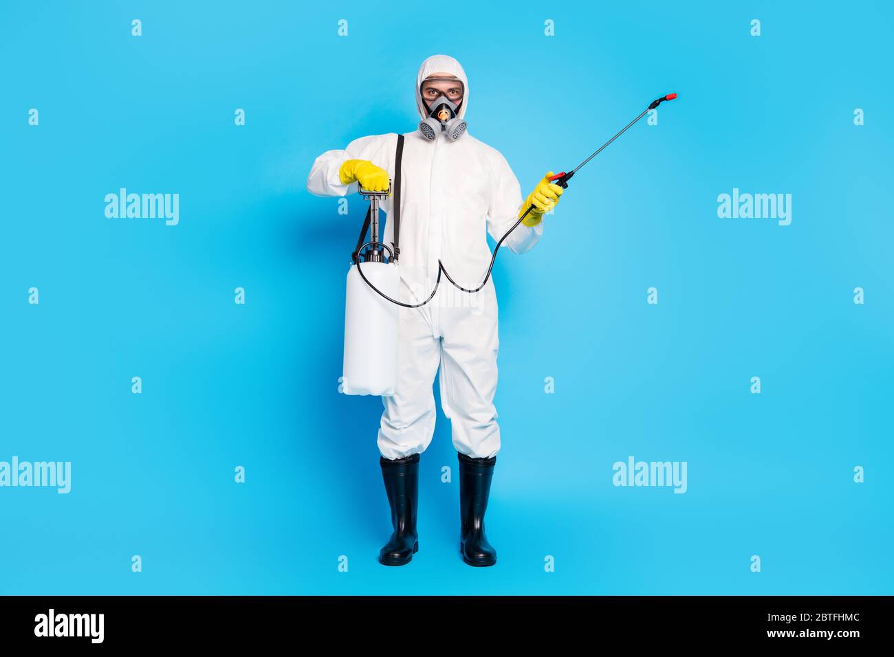 Full length photo medical worker man use equipment bottle disinfect ...