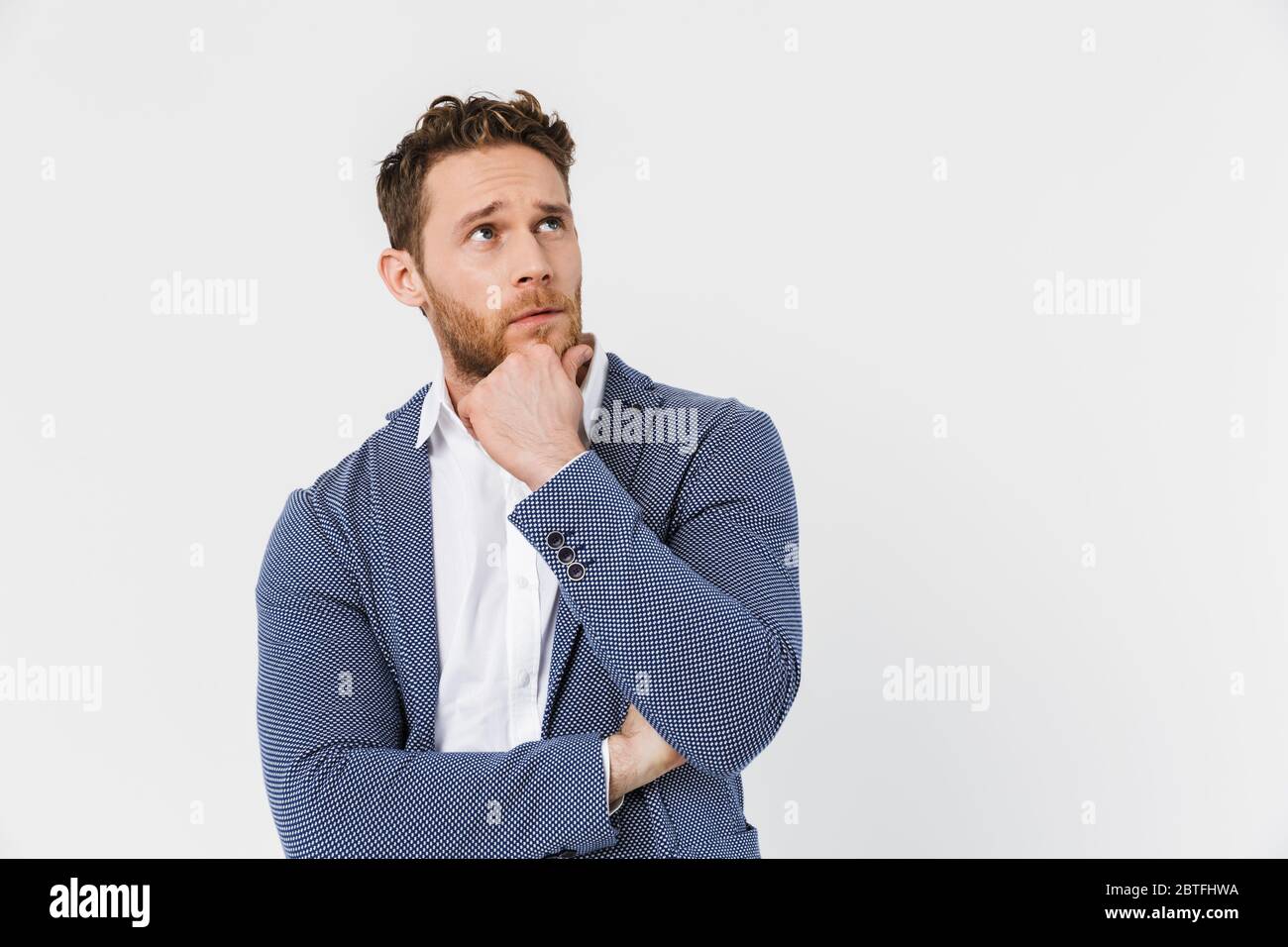 Image of thinking young man wearing jacket posing and looking upward ...