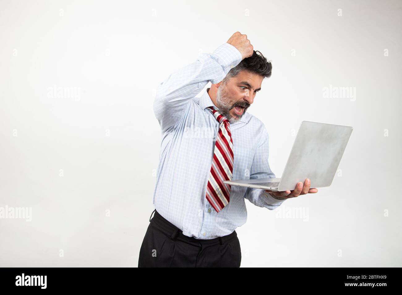 Furious businessman in a blue shirt and tie yelling and gesturing ...