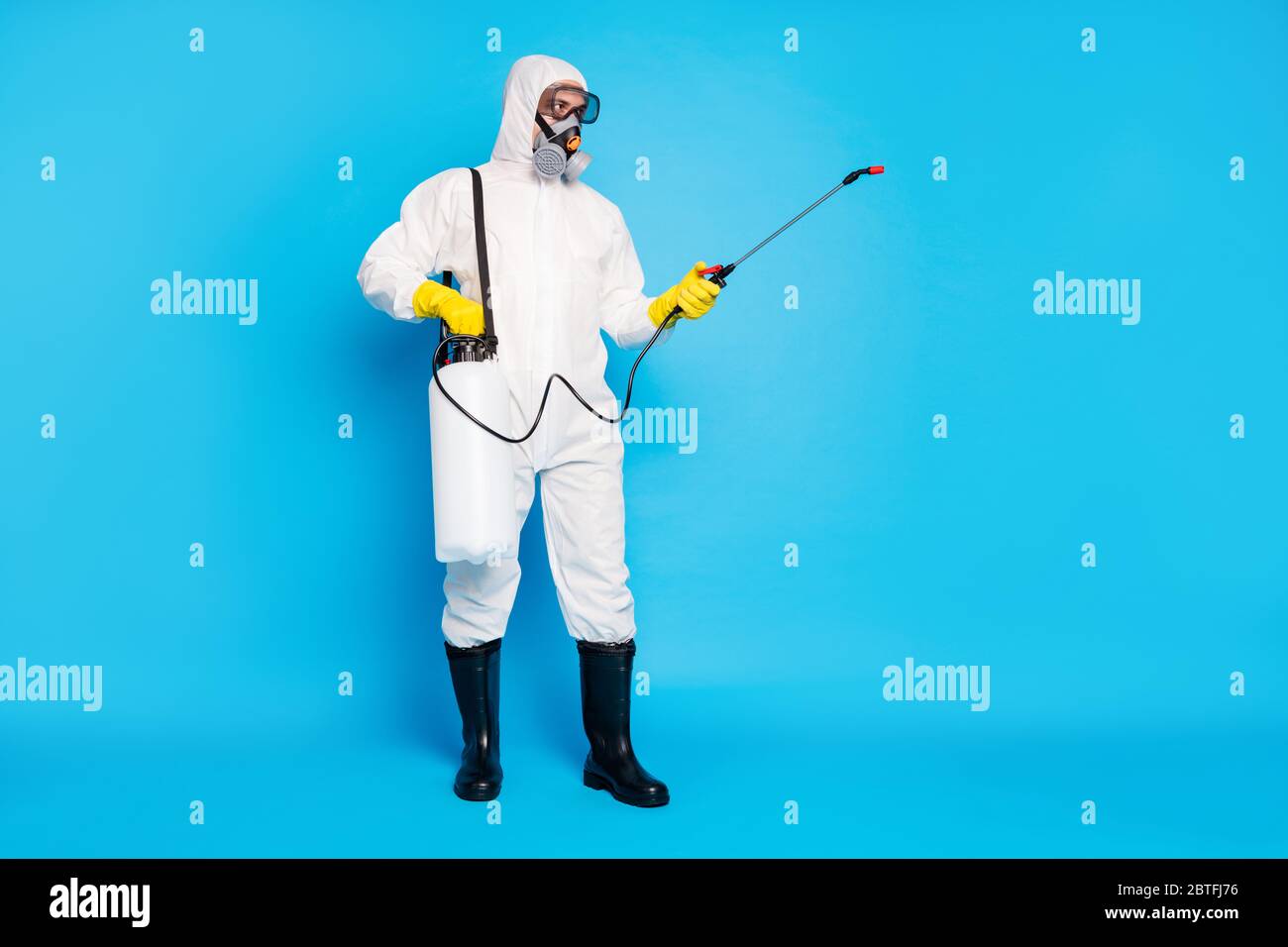 Full length photo of medical worker man use sprayer equipment disinfect ...