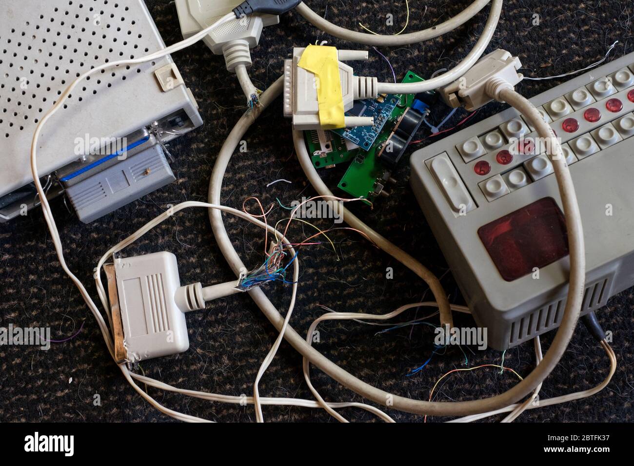 Abstract electronic devices and cables torn into pieces, indoor closeup ...