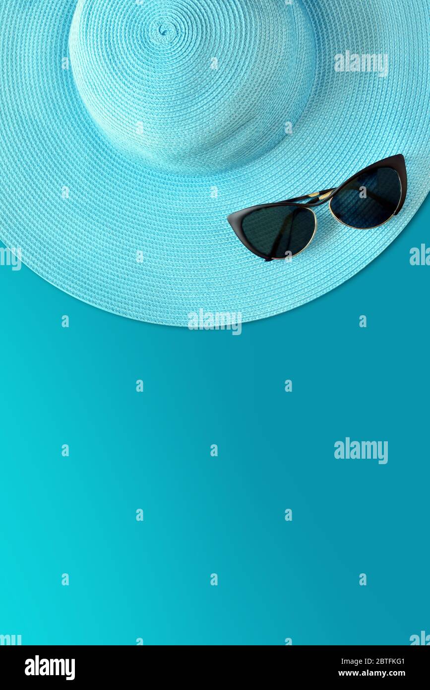 Summer hat with sunglasses. Top view, minimal concept over a blue ...