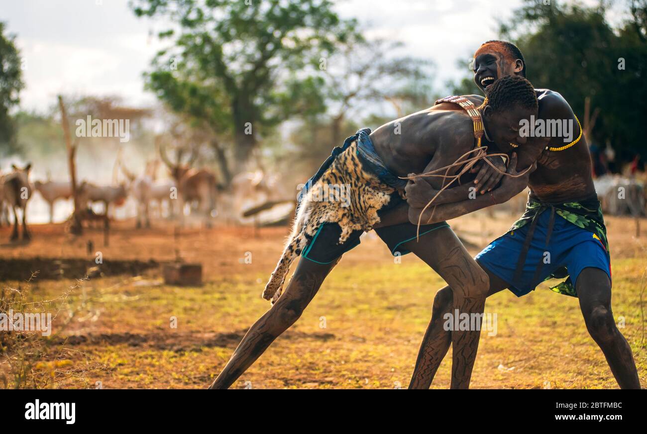 MUNDARI TRIBE, SOUTH SUDAN - MARCH 11, 2020: Young men smiling and ...