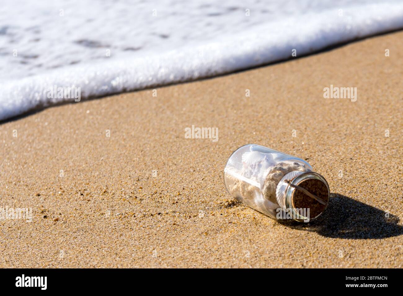 glass bottle with see shells washed ashore Stock Photo - Alamy