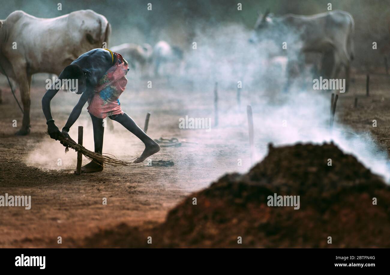 MUNDARI TRIBE, SOUTH SUDAN - MARCH 11, 2020: Man swinging bunch of ...