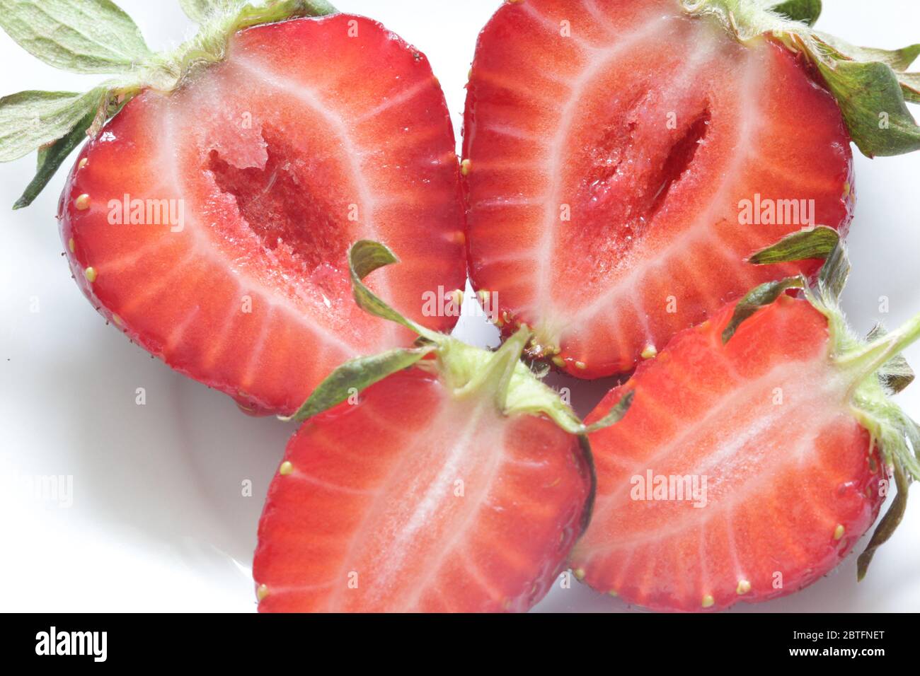 Fresh red strawberry cut in half on a white background. Healthy food ...