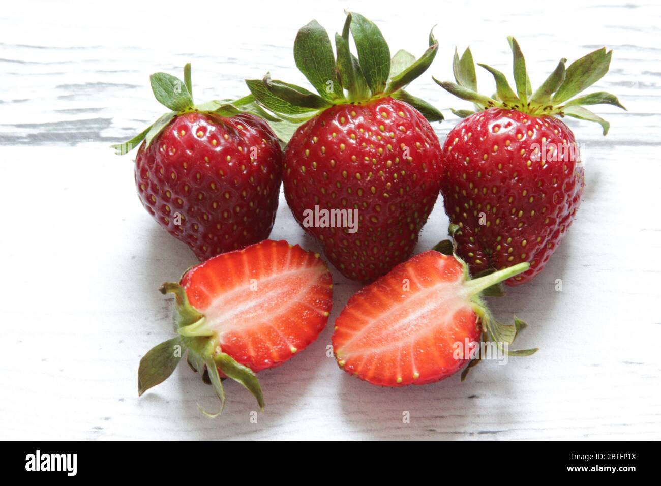 Fresh red strawberry cut in half on a white background. Healthy food ...