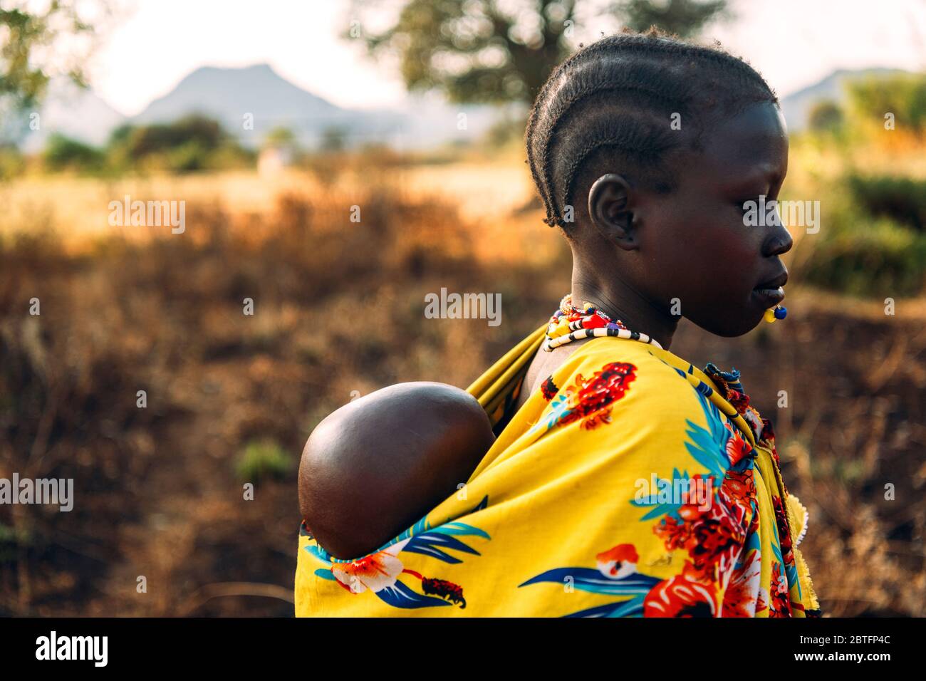 BOYA TRIBE, SOUTH SUDAN - MARCH 10, 2020: Girl in traditional colorful ...