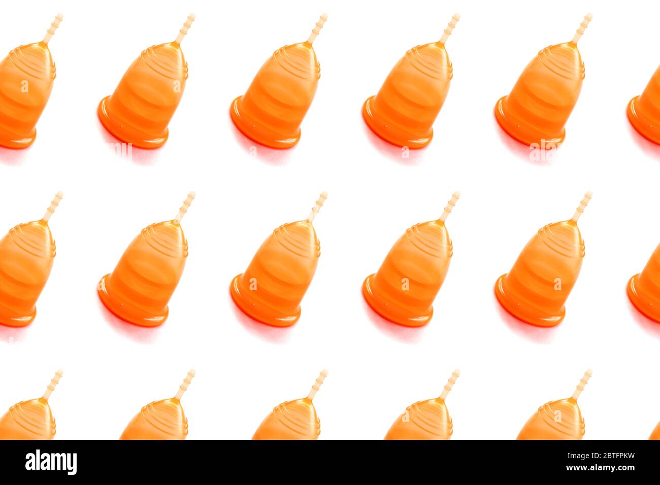 Pattern made from orange menstrual cup on white background. Isolated ...