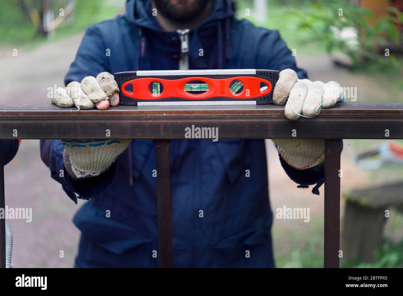 an engineer holding a level ruler on a top of metal construction Stock ...