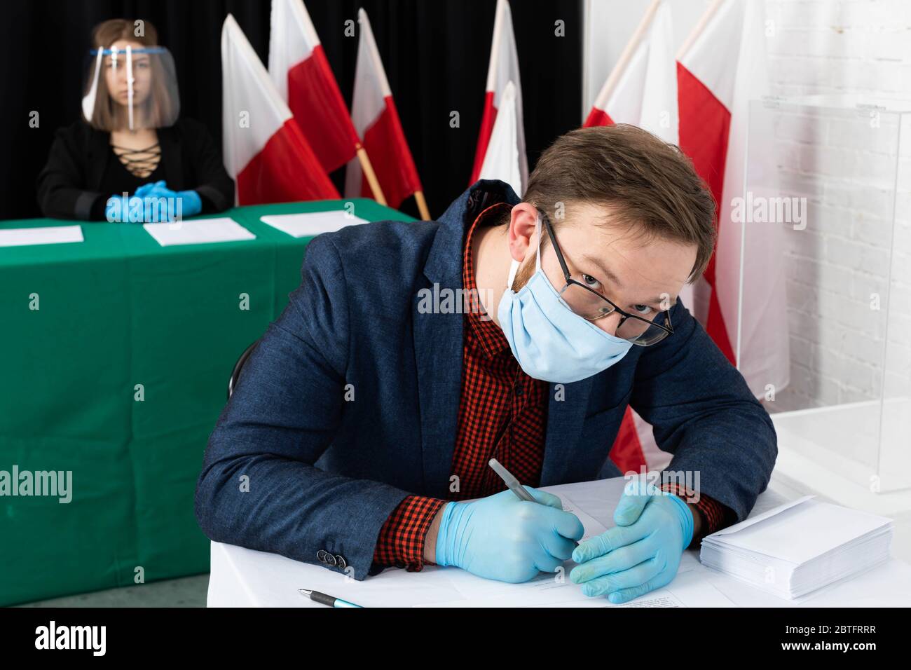 The young voter sits in a chair at the polling station and fills out ...