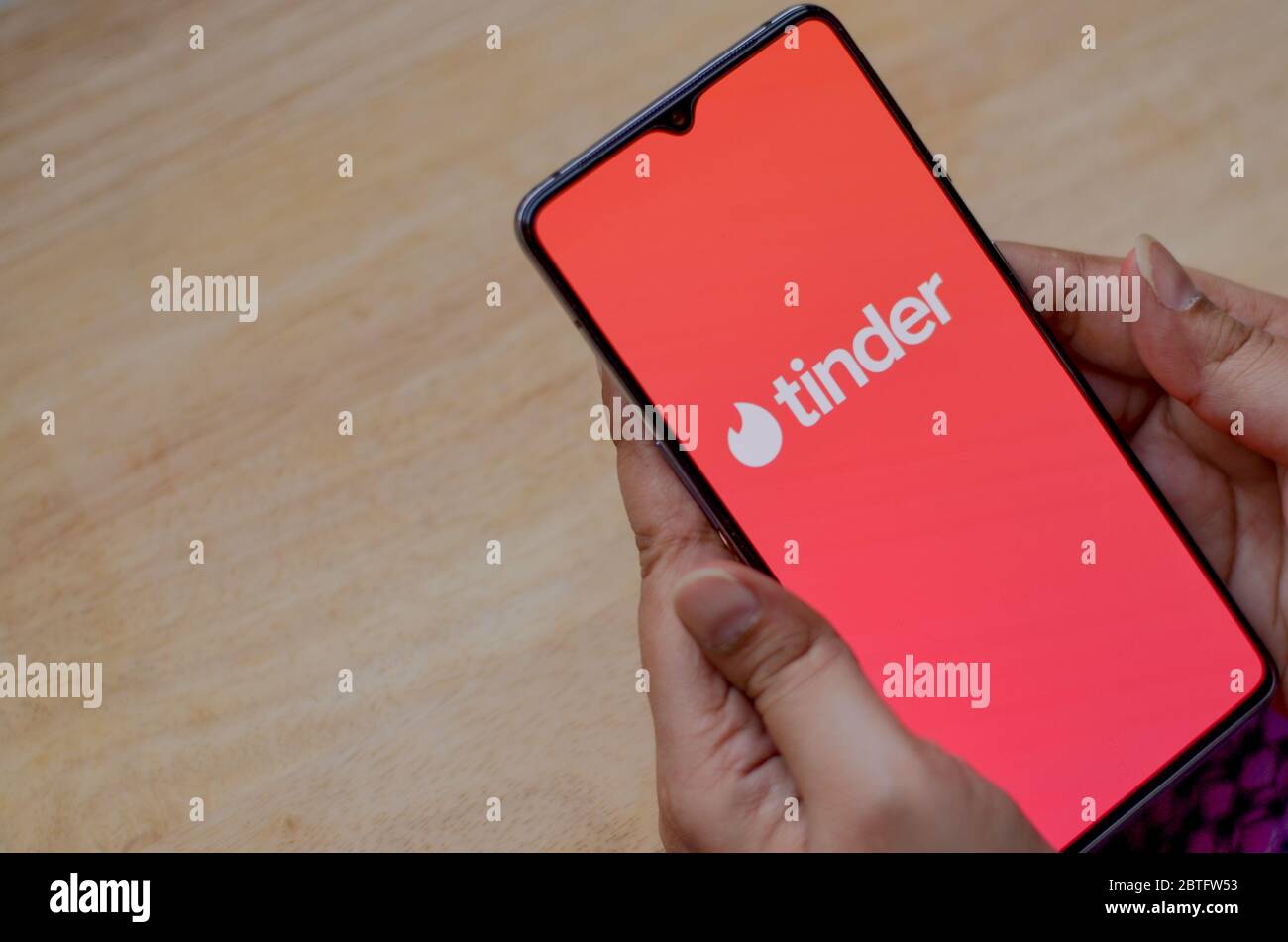 Chicago, USA, 2020. Flat lay with wooden background and Tinder app logo ...