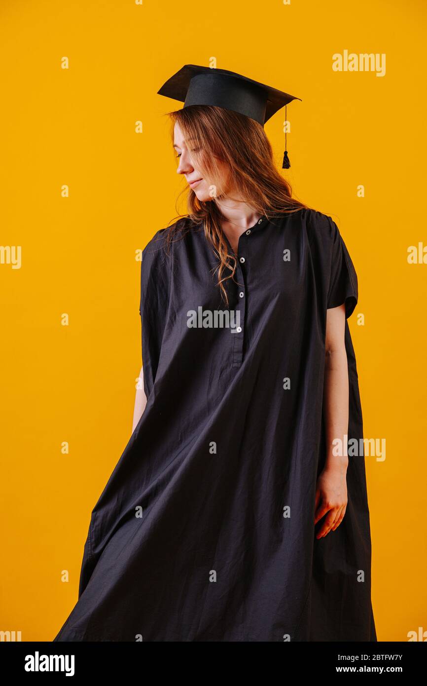 Woman in graduation gown and hat over orange background Stock Photo - Alamy