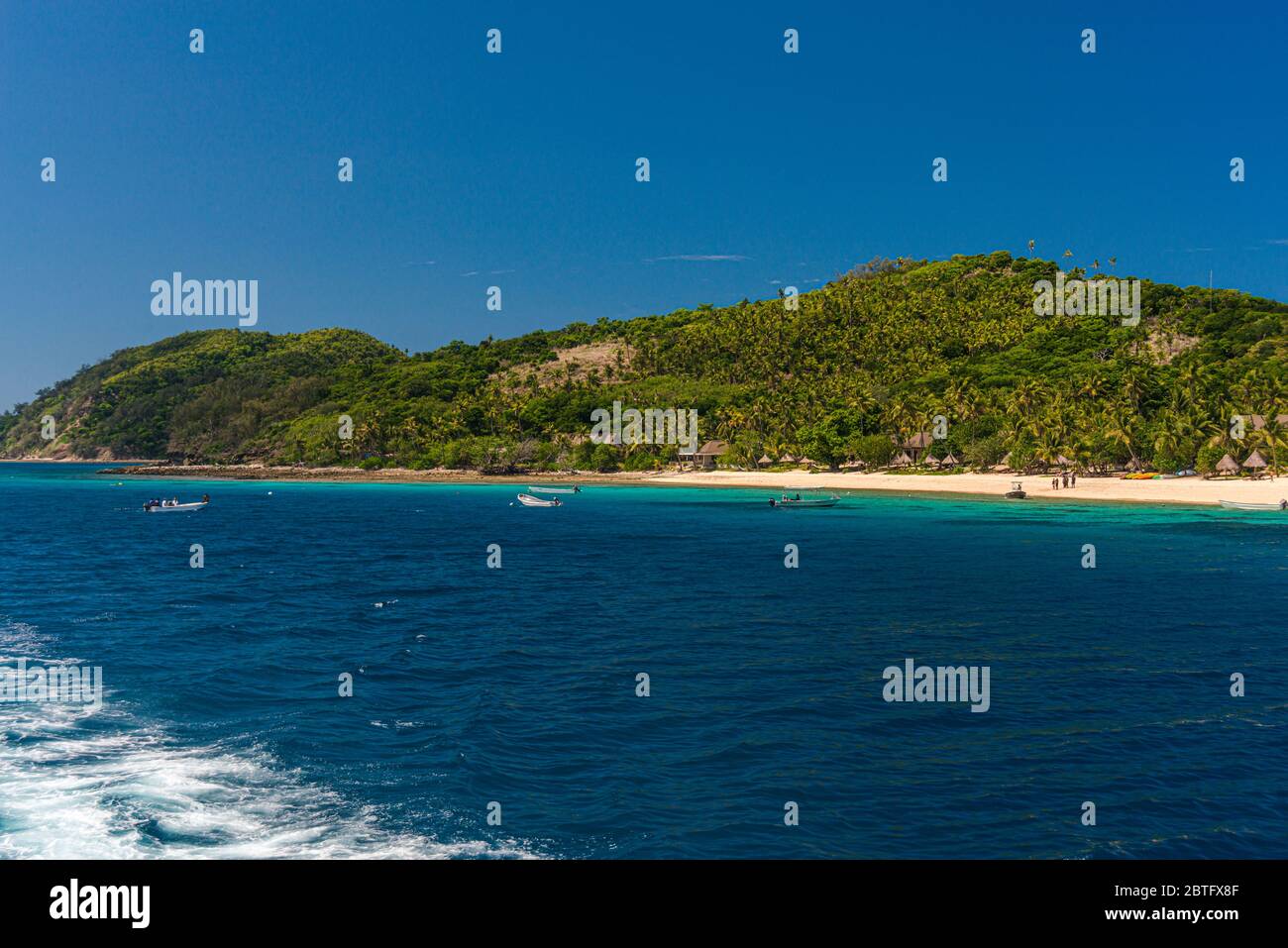 Deep blue water in front of the beachline of a tropical island of Fiji ...