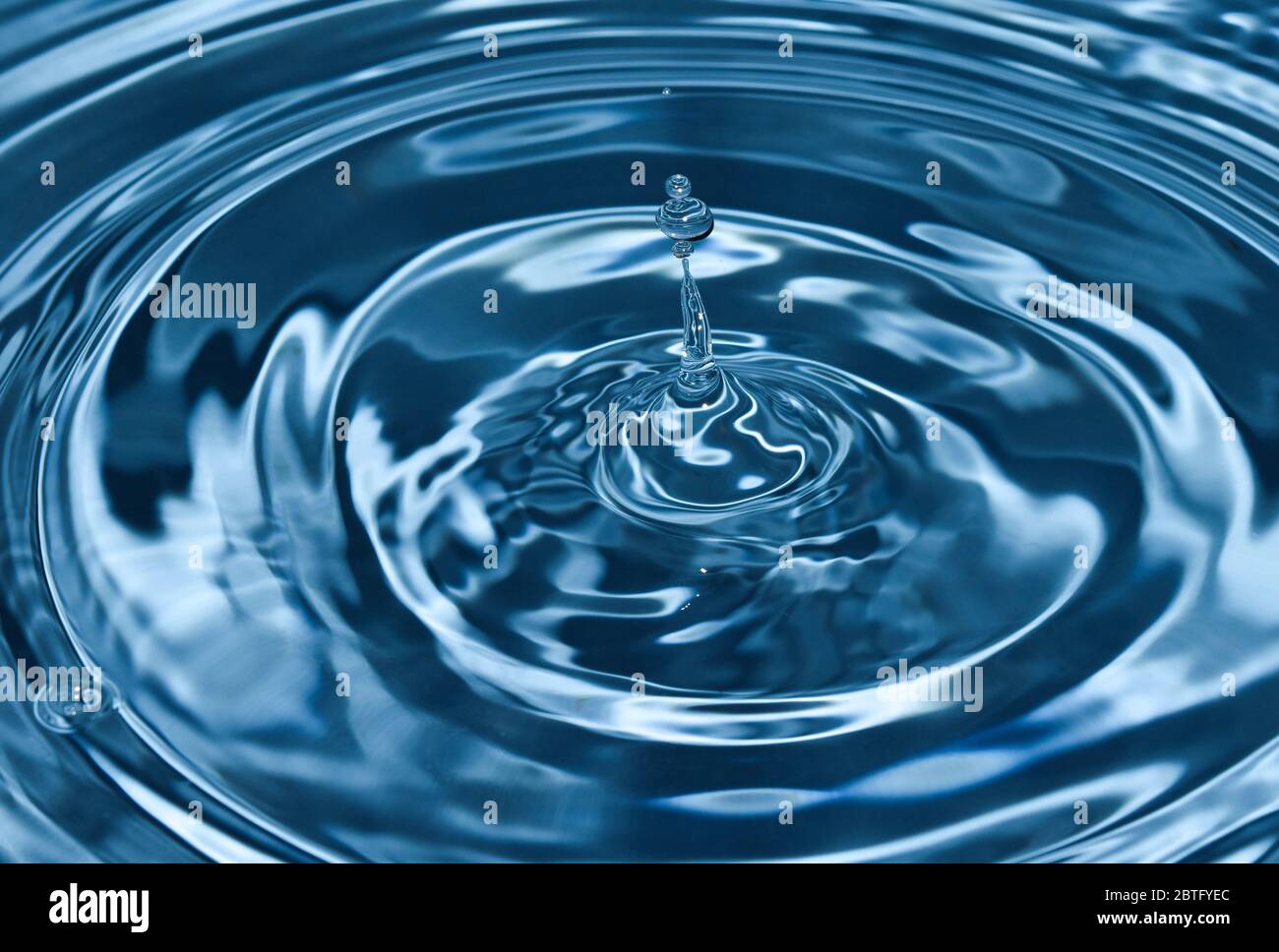 splash of falling drops of water creating circles on the surface of the ...