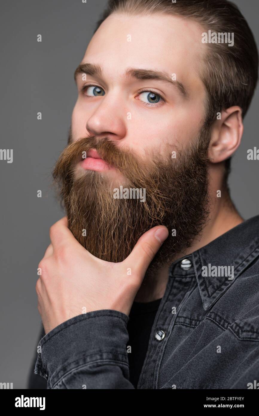 portrait of thinking stylish young man touch his beard Stock Photo - Alamy