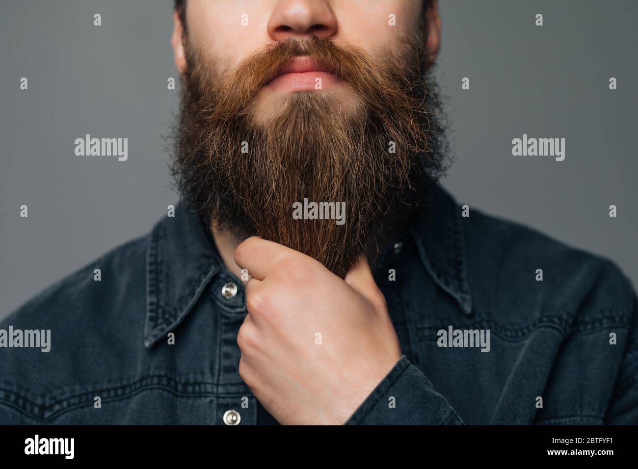 Touching his perfect beard. Close-up of bearded man touching his beard ...